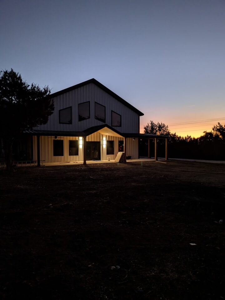 Two-Story White Texas Barndominium with Wraparound Porch